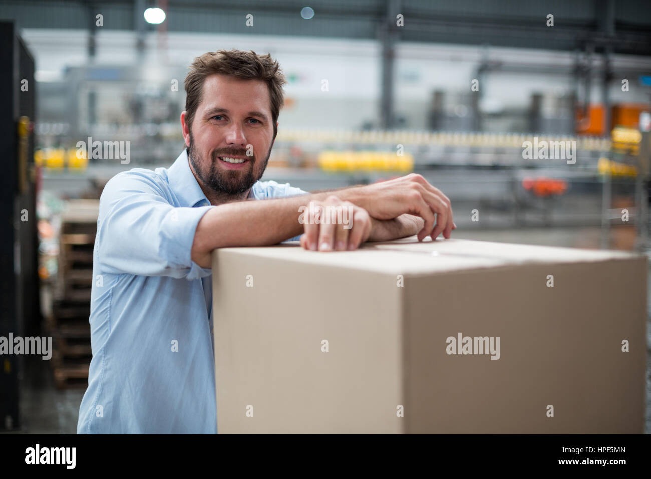 Portrait of smiling factory worker standing in factory Stock Photo - Alamy