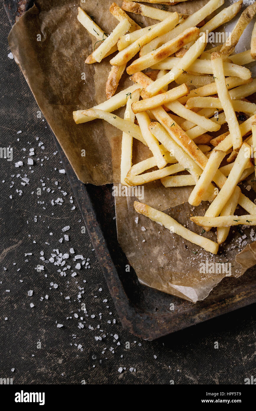 Fast food french fries potatoes with skin served with salt and herbs on ...