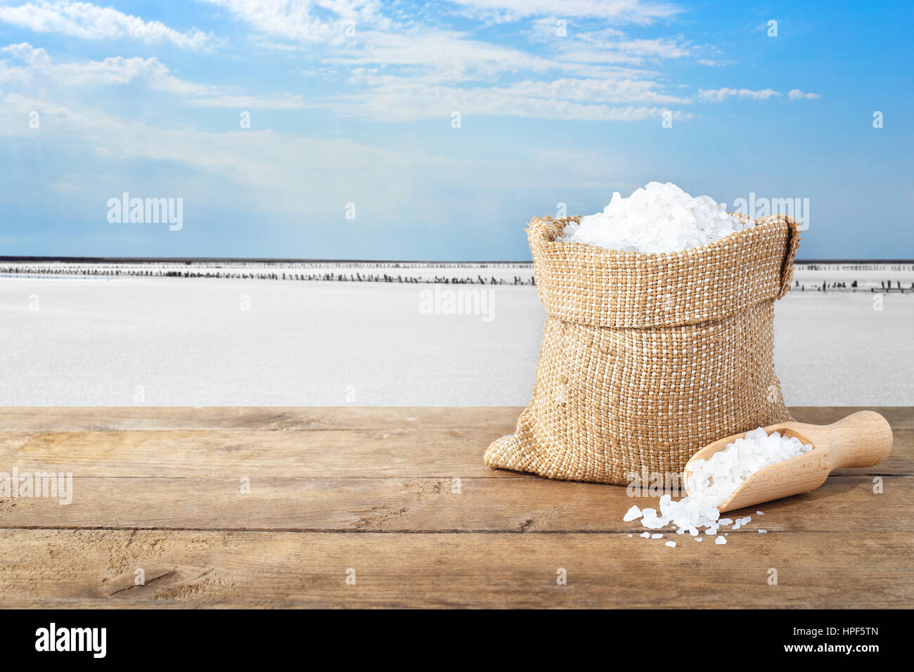 sea salt in bag. Crystals of salt in sack on table with salty lake in ...
