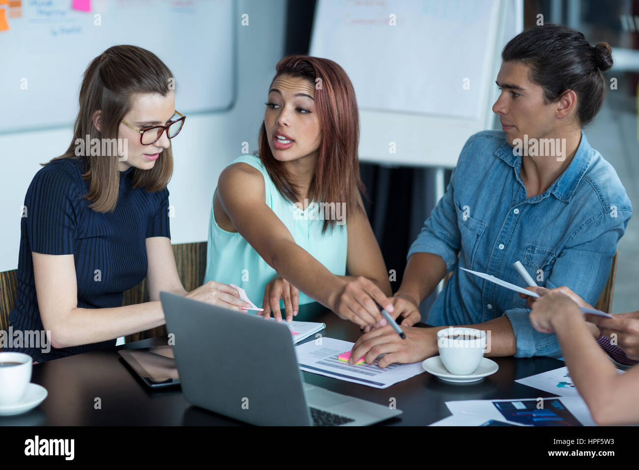 Business executives discussing during meeting in office Stock Photo - Alamy