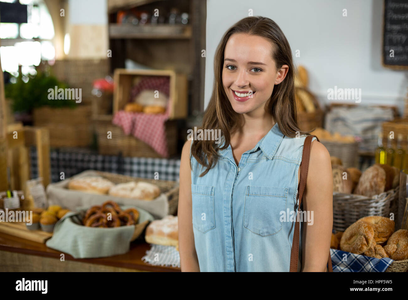 Portrait of smiling woman standing against counter in bake shop Stock ...