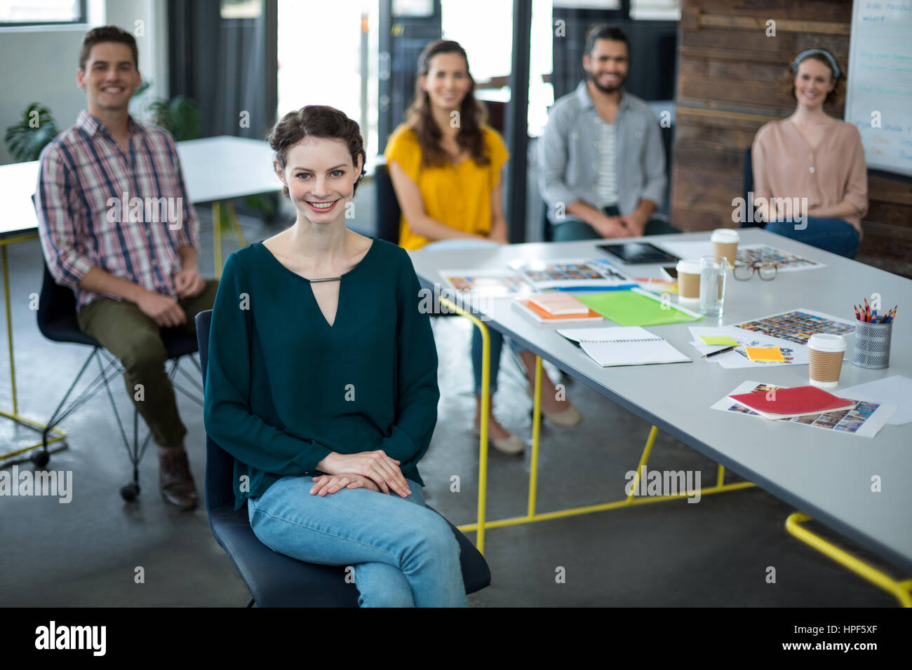 Portrait of smiling graphic designers sitting in office Stock Photo - Alamy