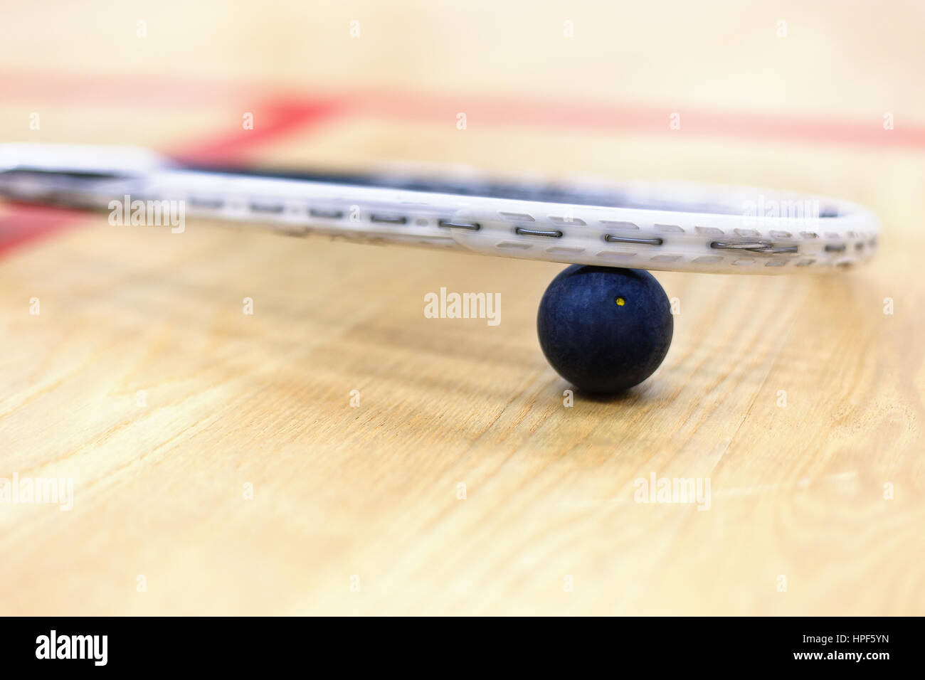Close up of a squash racket and ball on the wooden background ...