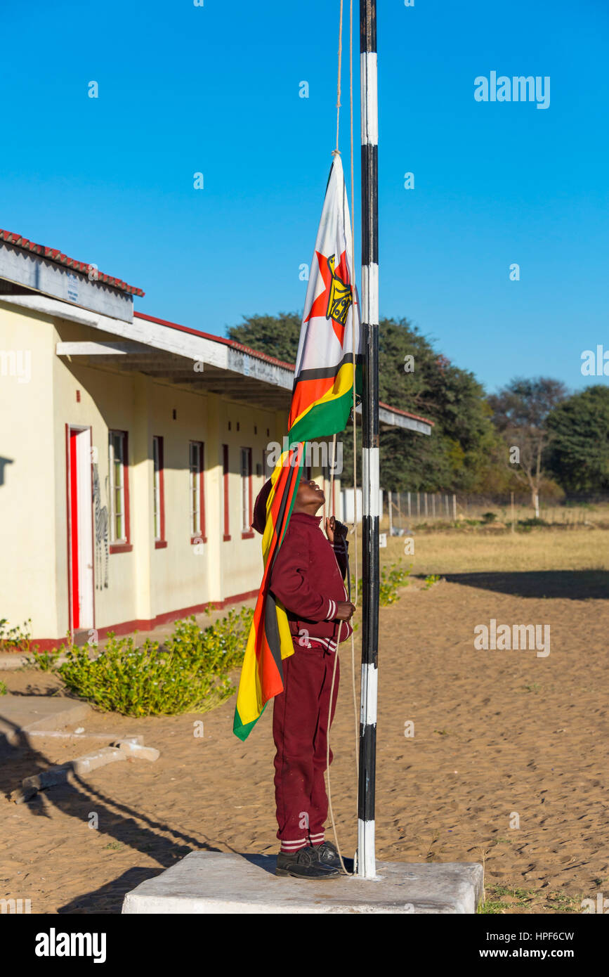 A school child raises the Zimbabwean flag at a rural school in ...