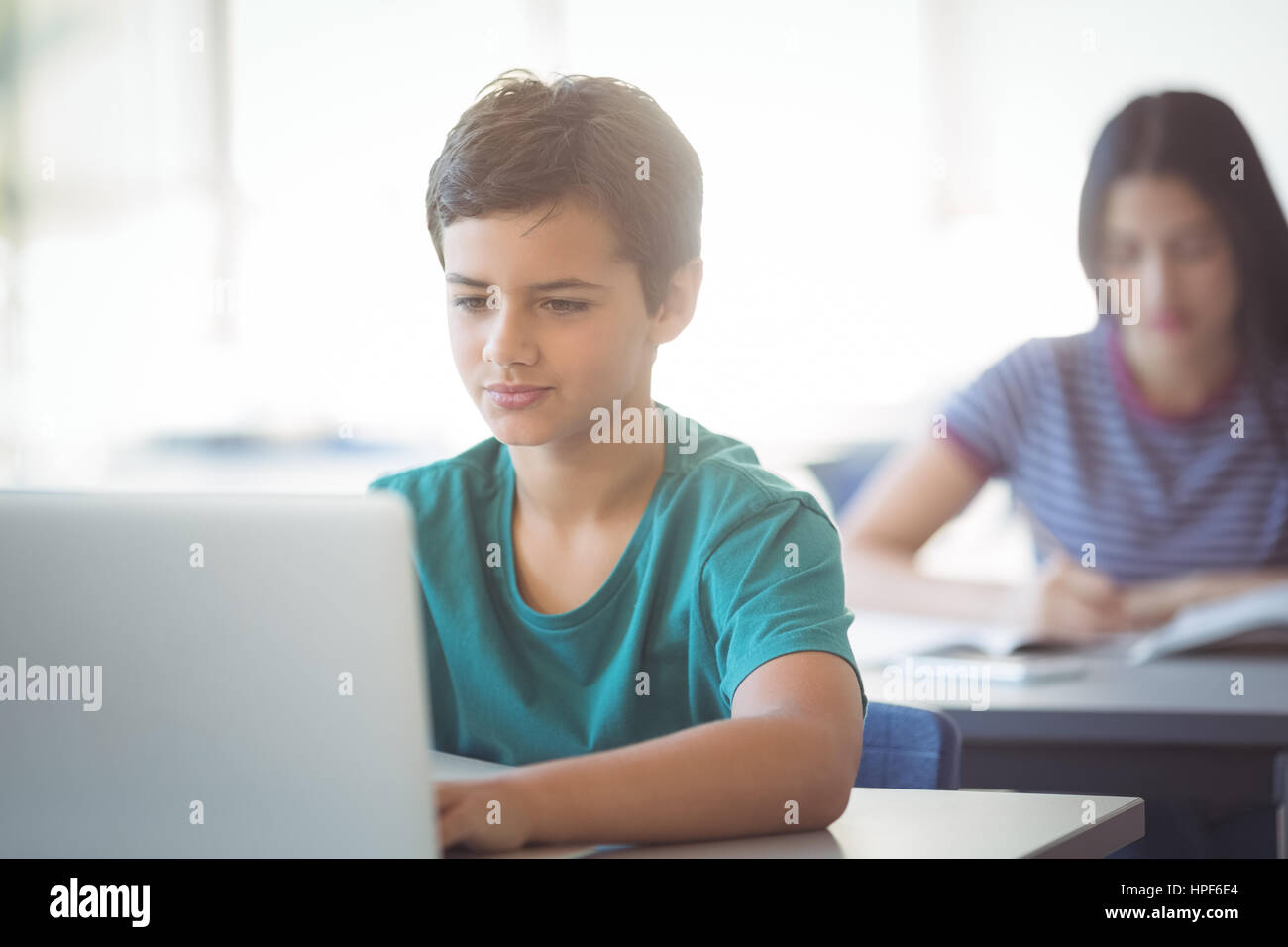 Schoolboy using laptop in classroom at school Stock Photo - Alamy