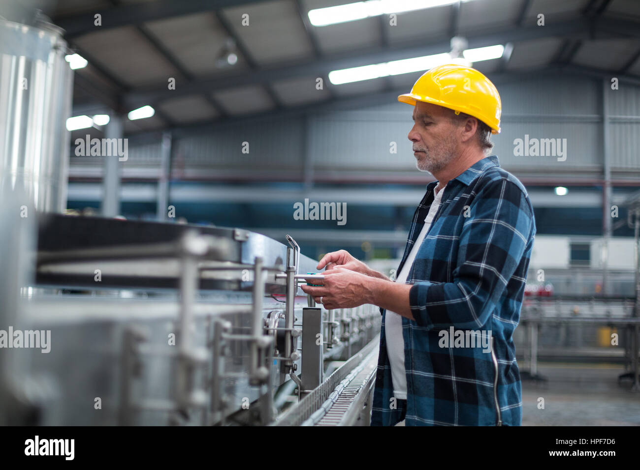 Factory worker monitoring production line in factory Stock Photo - Alamy