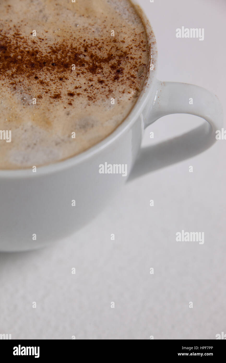 Close-up of white coffee cup with creamy froth on white background ...