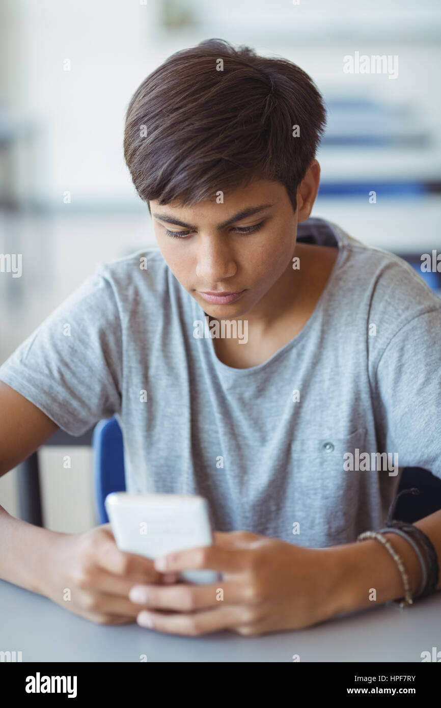 Schoolboy using mobile phone in classroom at school Stock Photo - Alamy