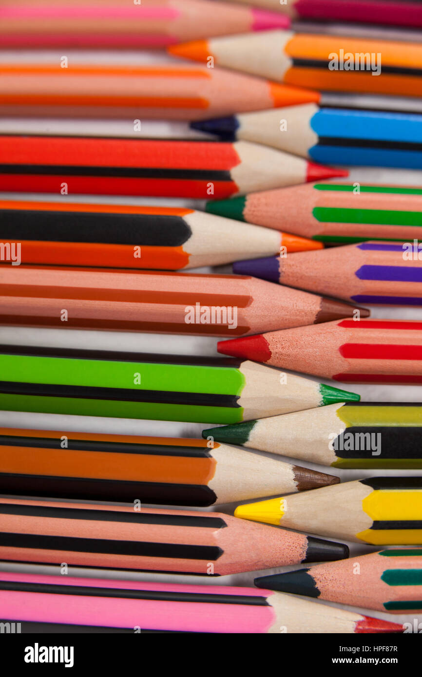 Close-up of colored pencils arranged in interlock pattern on white ...