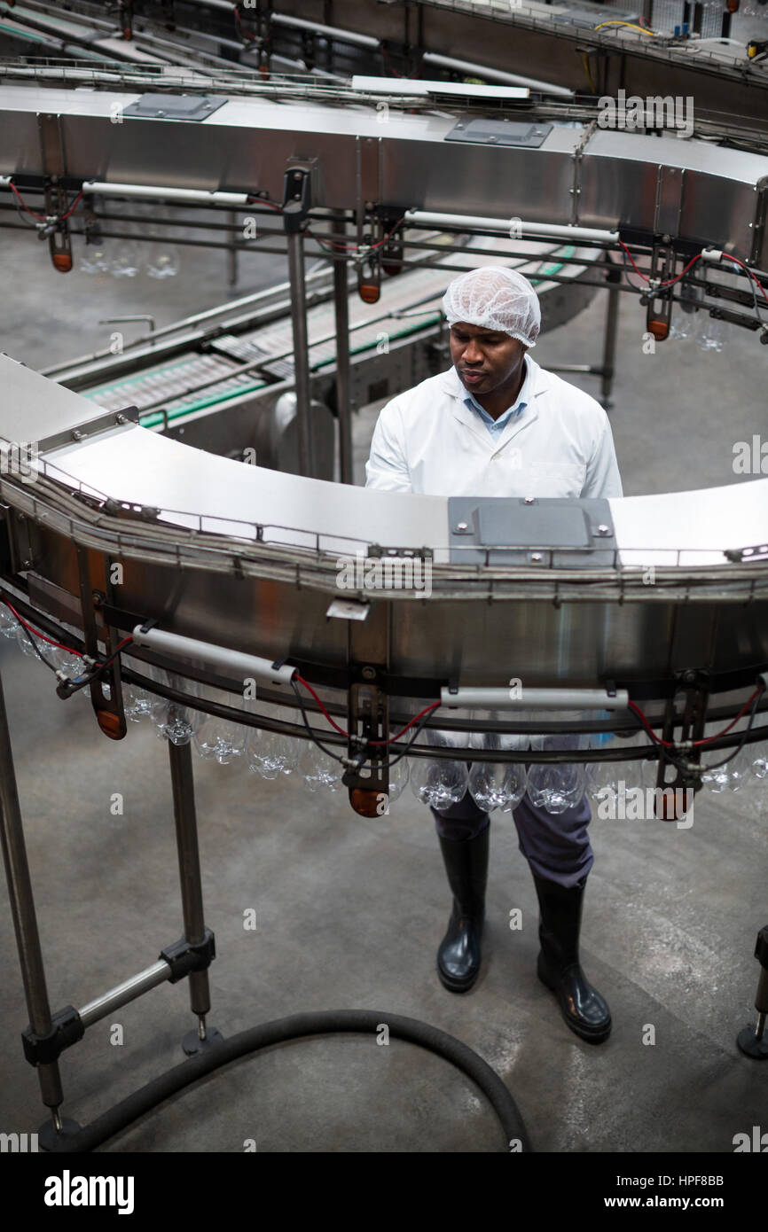 Factory engineer monitoring a production line in drinks production ...