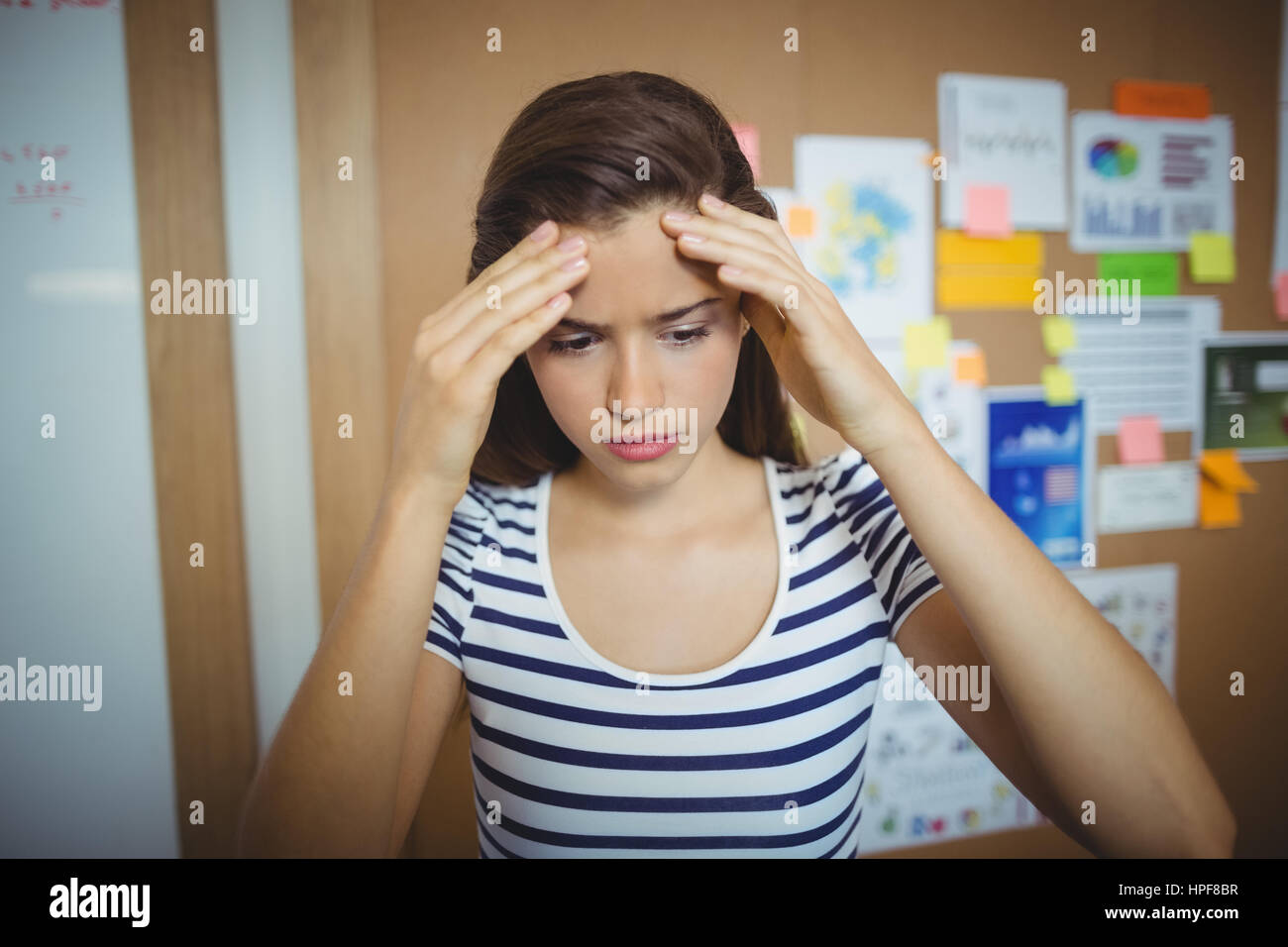 Worried female executive standing in office Stock Photo - Alamy