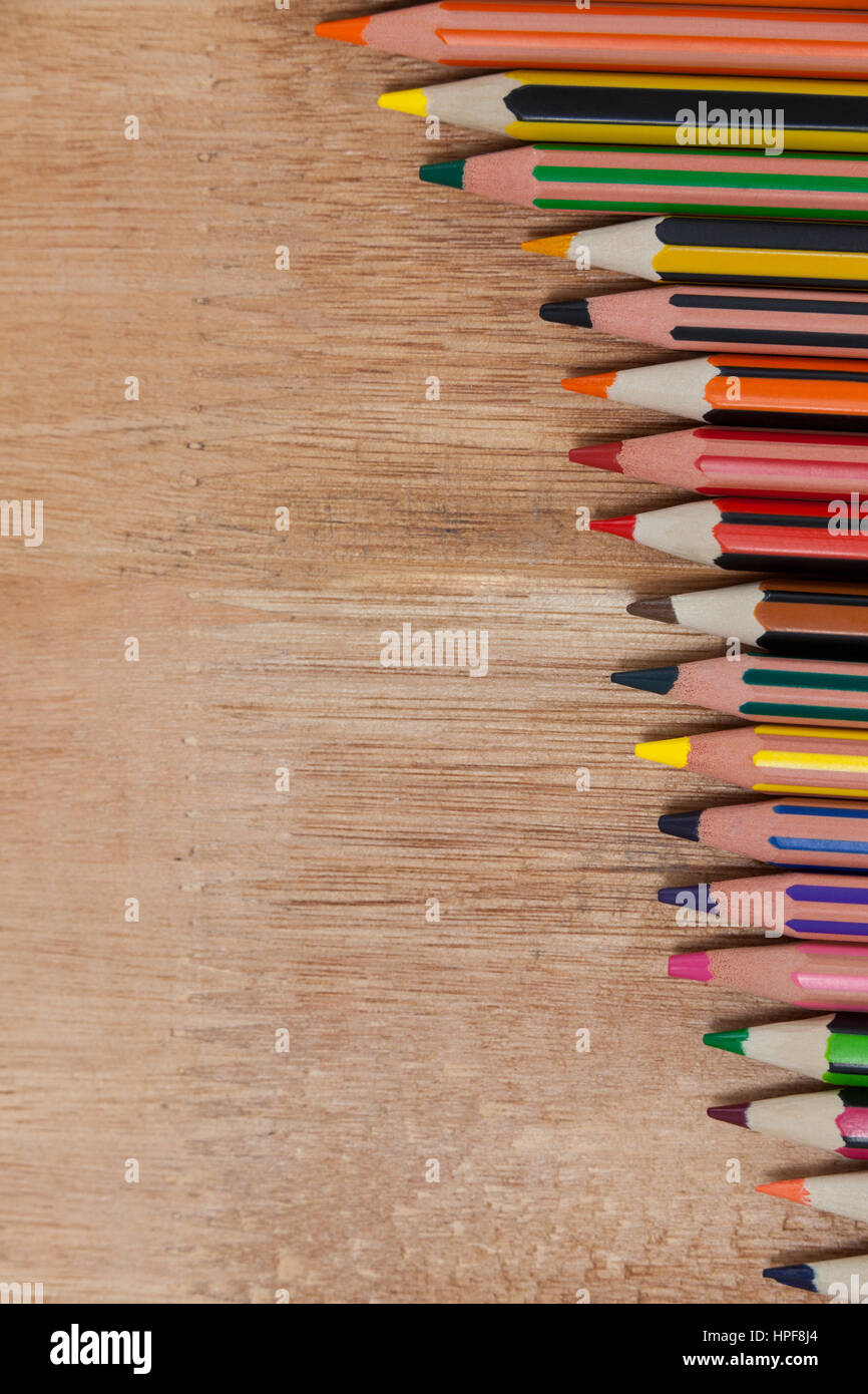 Colorful color pencil arranged in diagonal line on wooden background ...