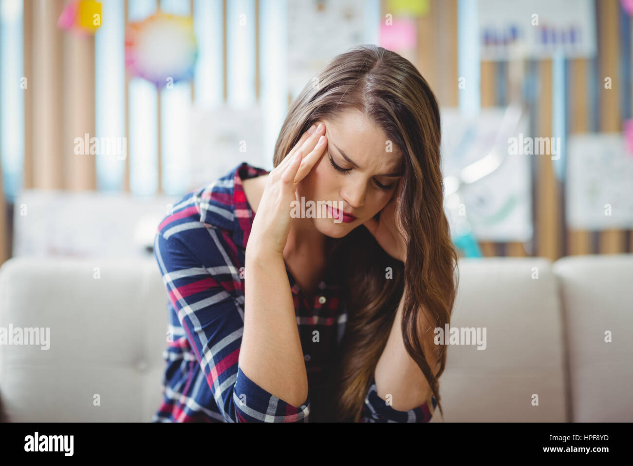 Stressed executive sitting on sofa in office Stock Photo - Alamy