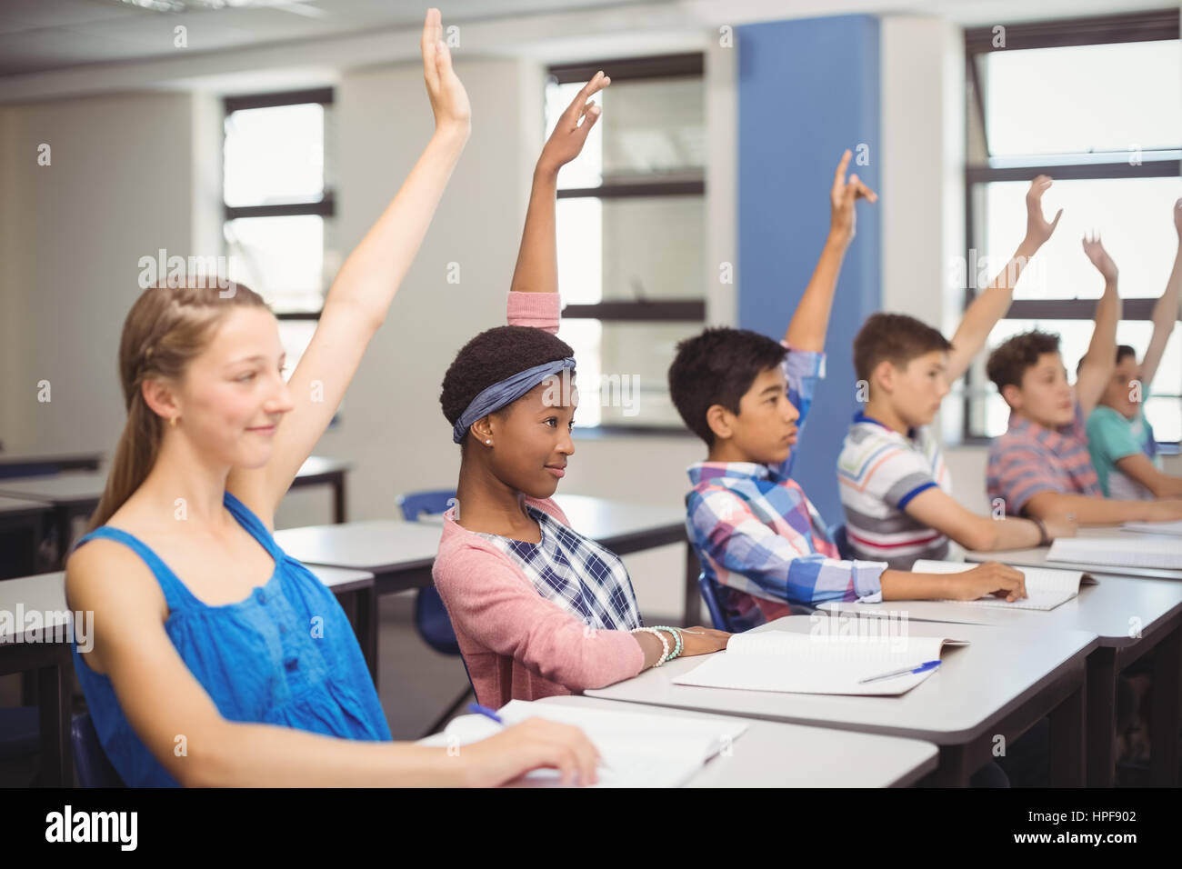 Student raising hand in classroom at school Stock Photo - Alamy
