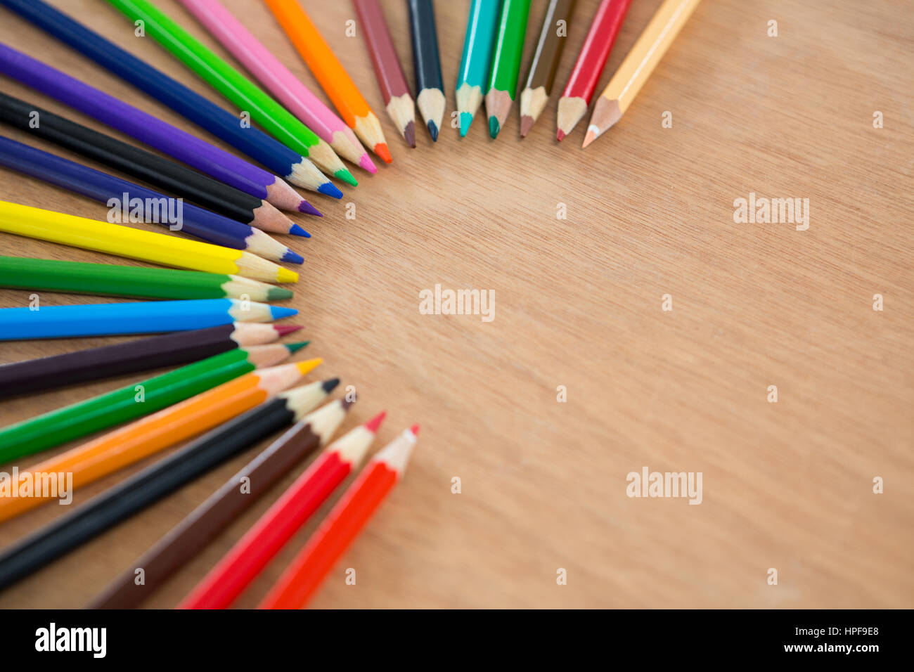Colored pencils arranged in semi circle on wooden background Stock ...