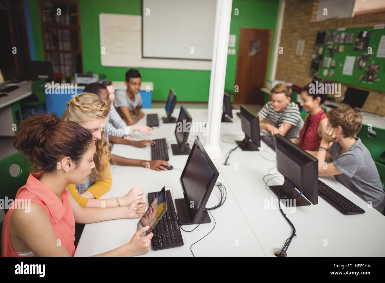 Smiling students studying in computer classroom at school Stock Photo ...