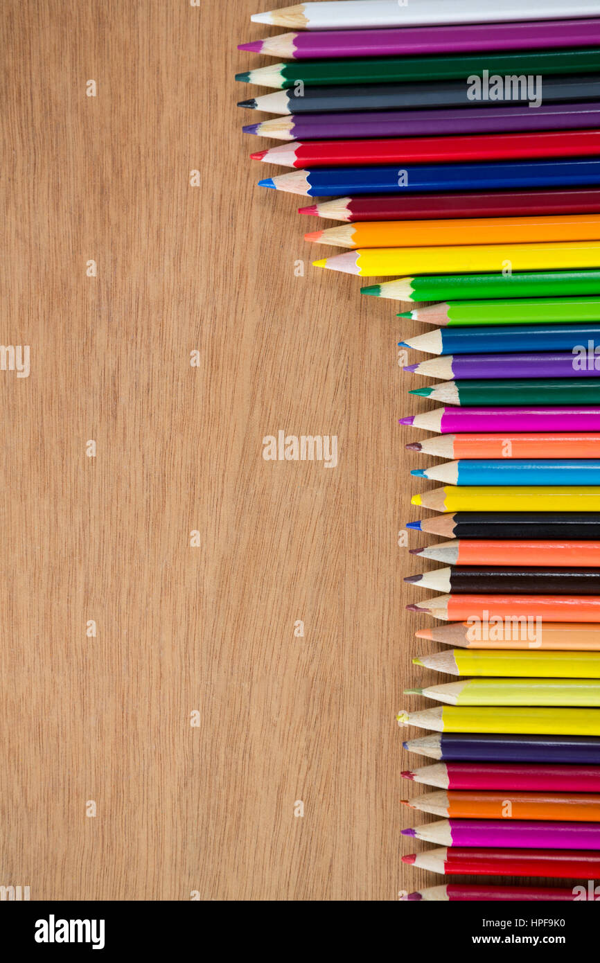 Colored pencils arranged in diagonal line on wooden background Stock ...
