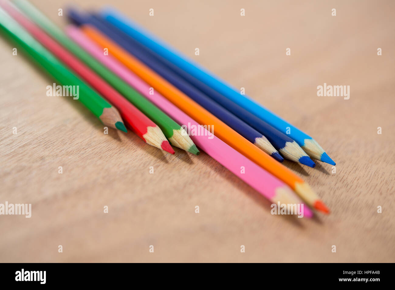 Colored pencils arranged in diagonal line on wooden background Stock ...