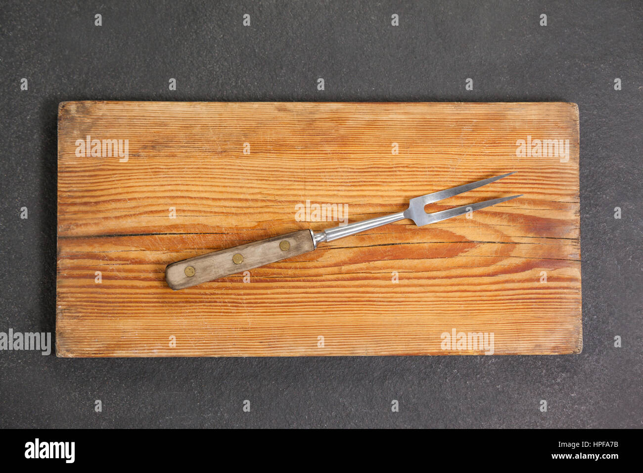 Fork on wooden board against black background Stock Photo - Alamy