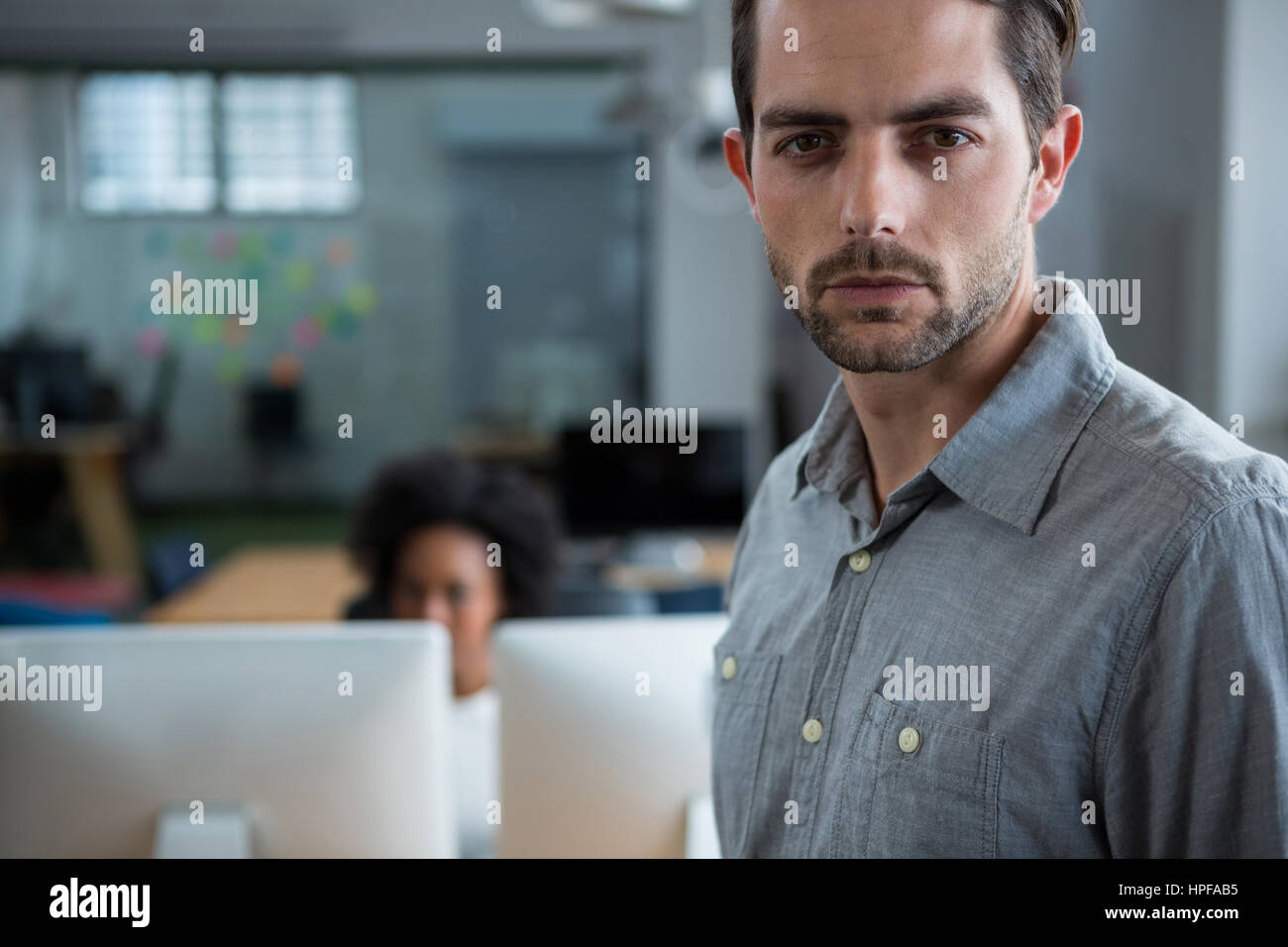 Portrait of a serious man standing in creative office Stock Photo - Alamy