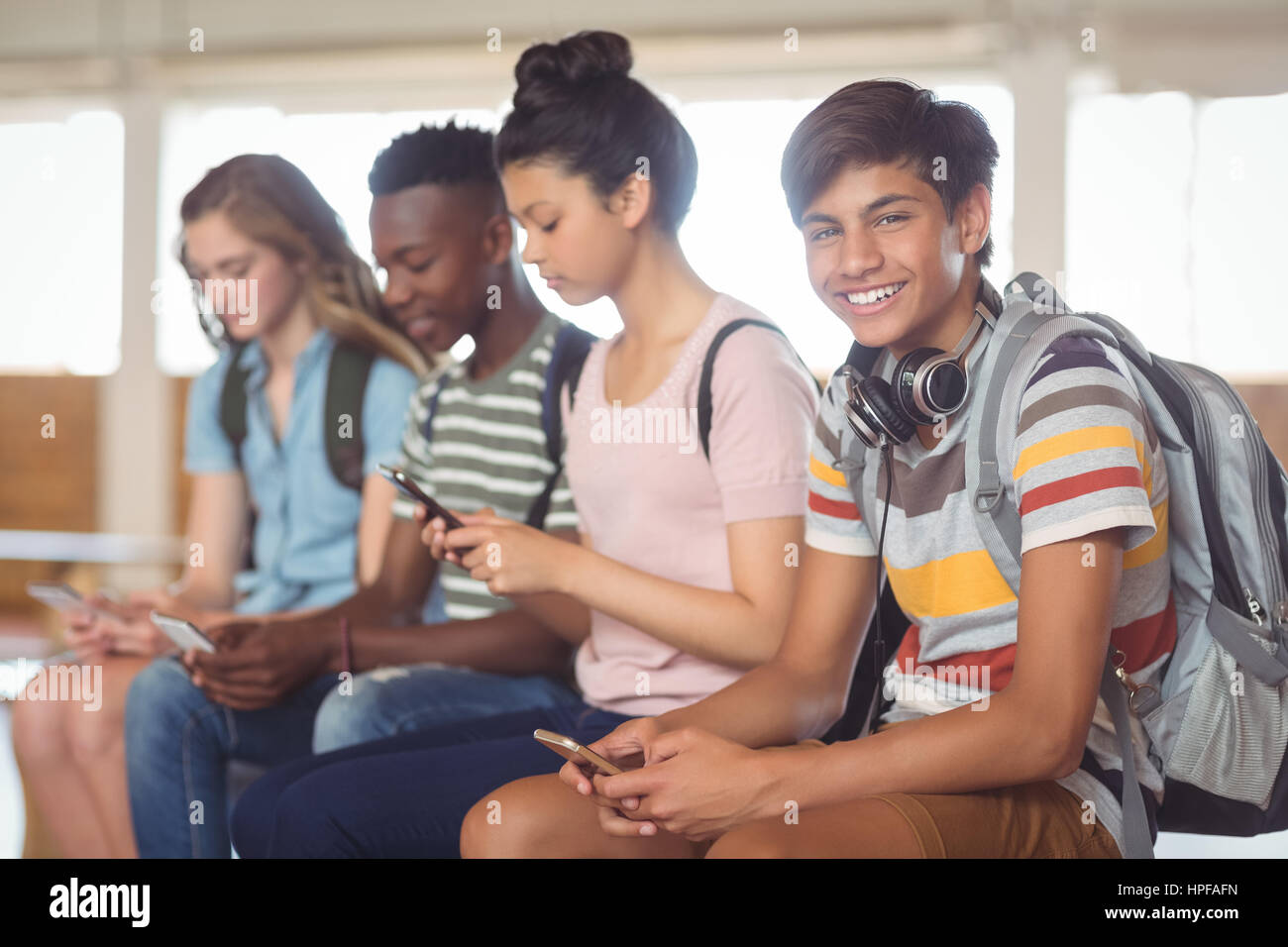 Students using mobile phone in campus at school Stock Photo - Alamy