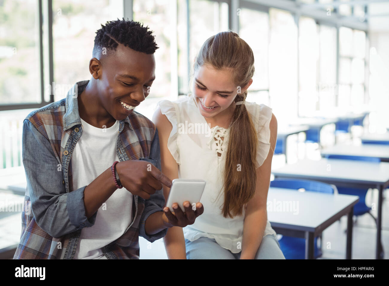 Schoolkids using mobile phone in classroom at school Stock Photo - Alamy