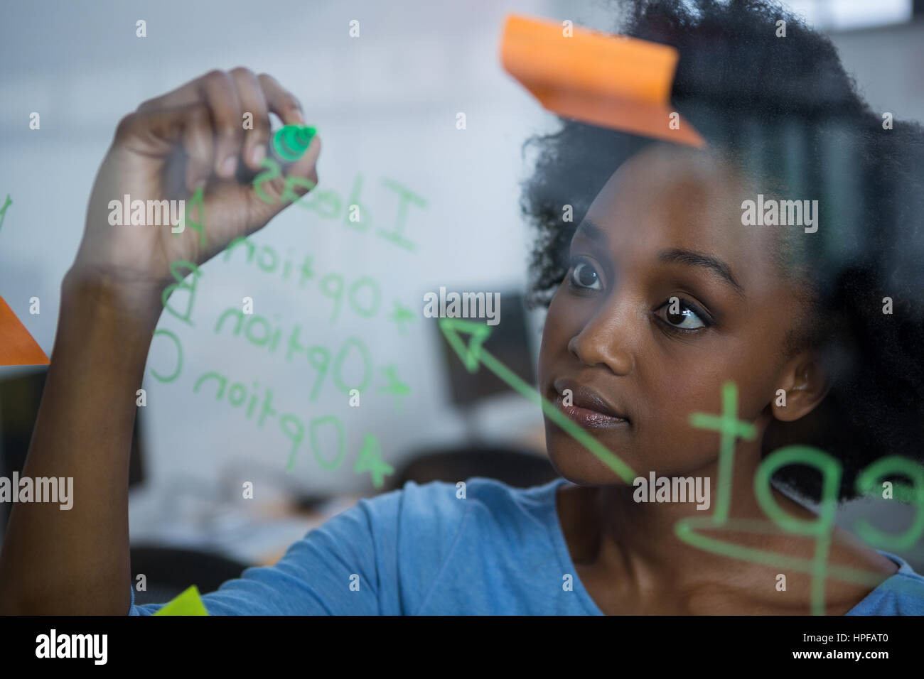 Female graphic designer writing on glass with marker Stock Photo - Alamy