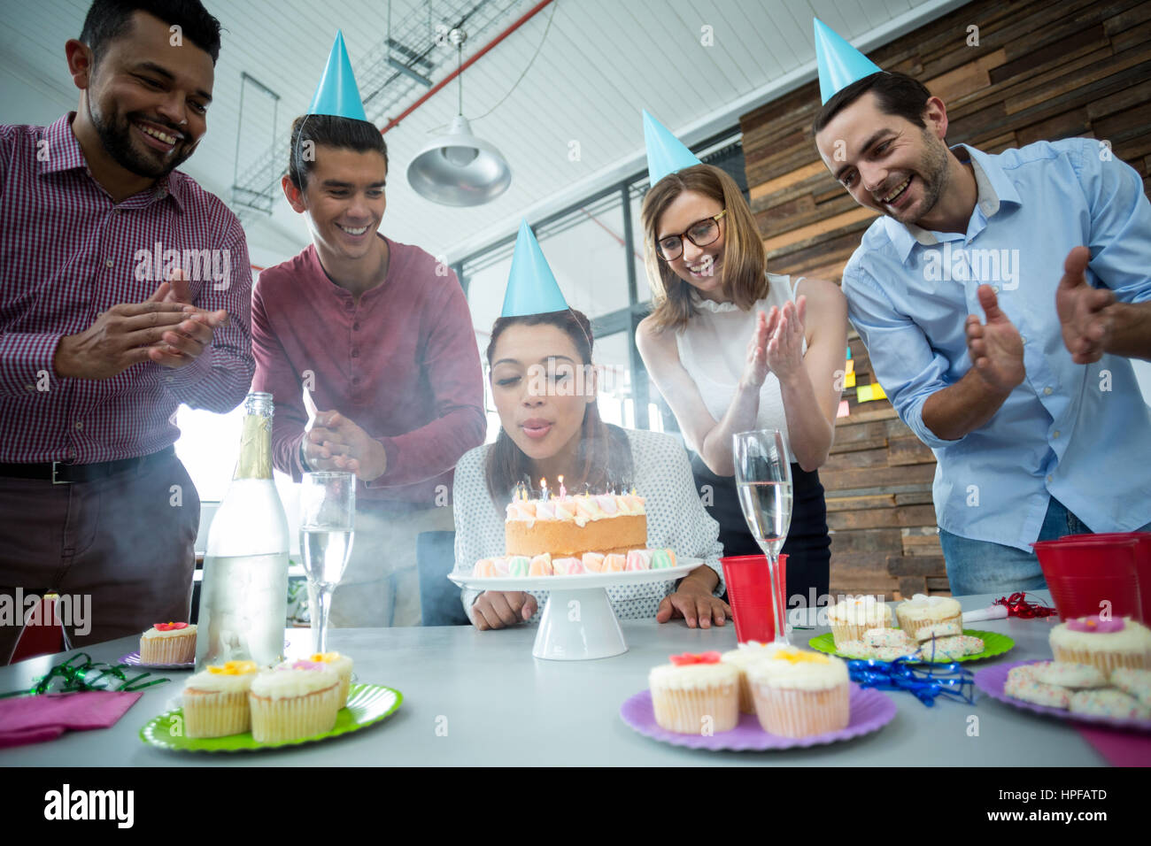 Businesspeople celebrating their colleagues birthday in office Stock ...