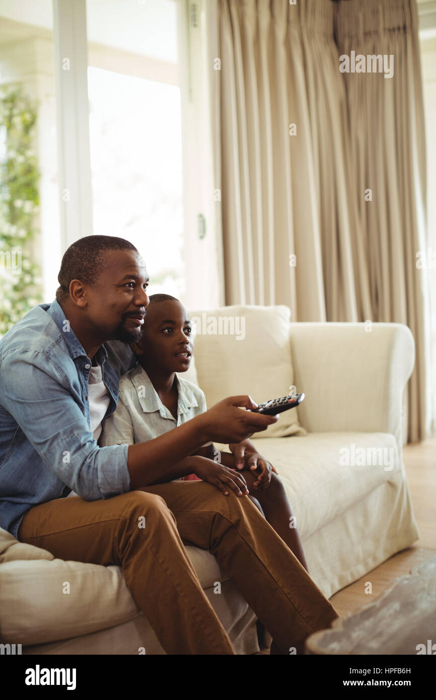 Son and father watching television at home Stock Photo - Alamy