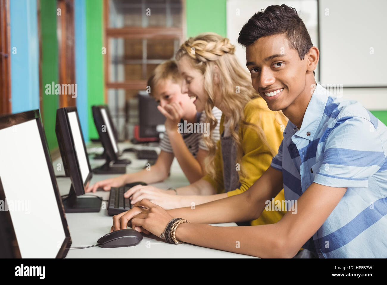 Smiling students studying in computer classroom at school Stock Photo ...