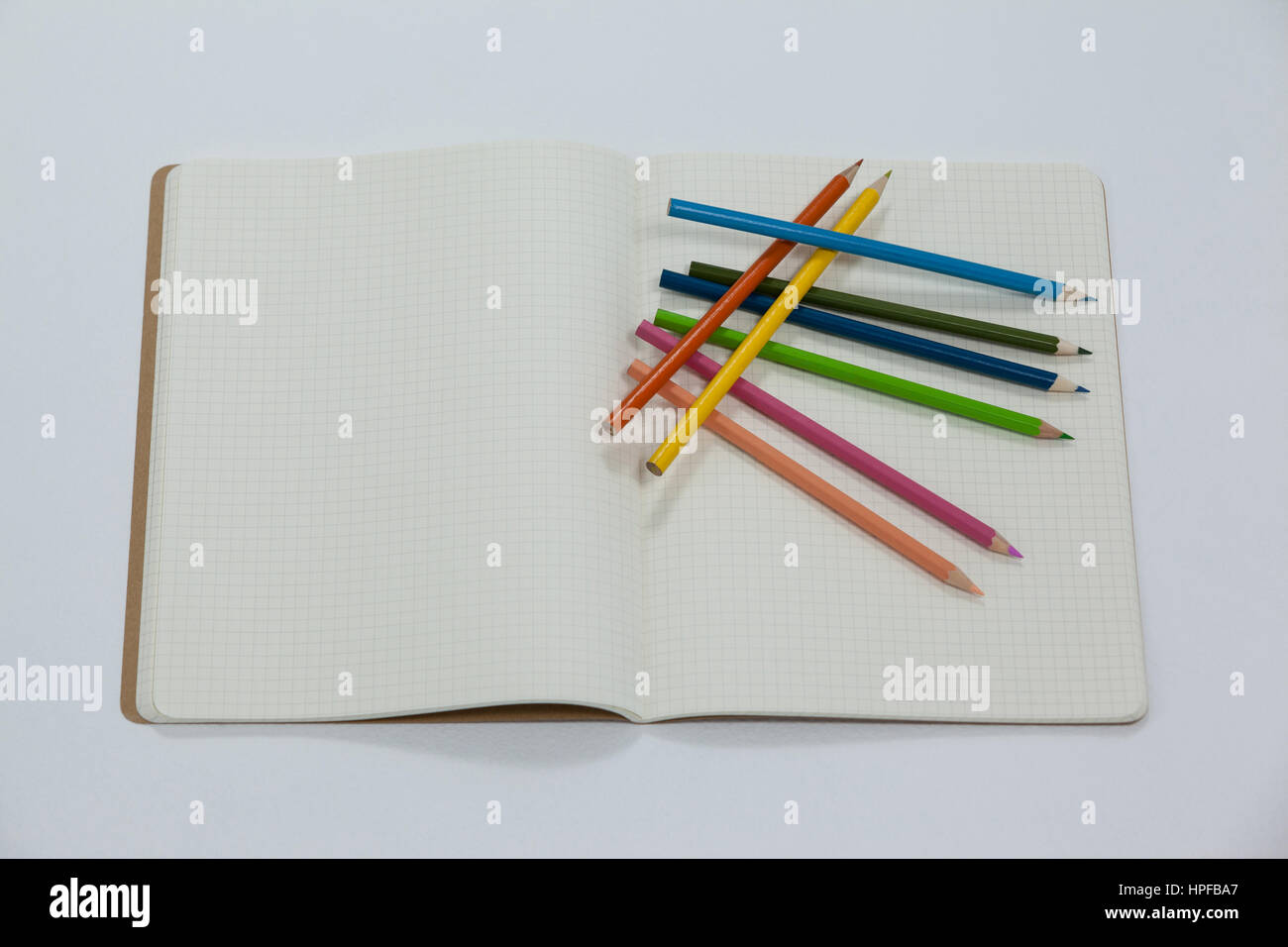 Colored pencils and notebook on white background Stock Photo - Alamy