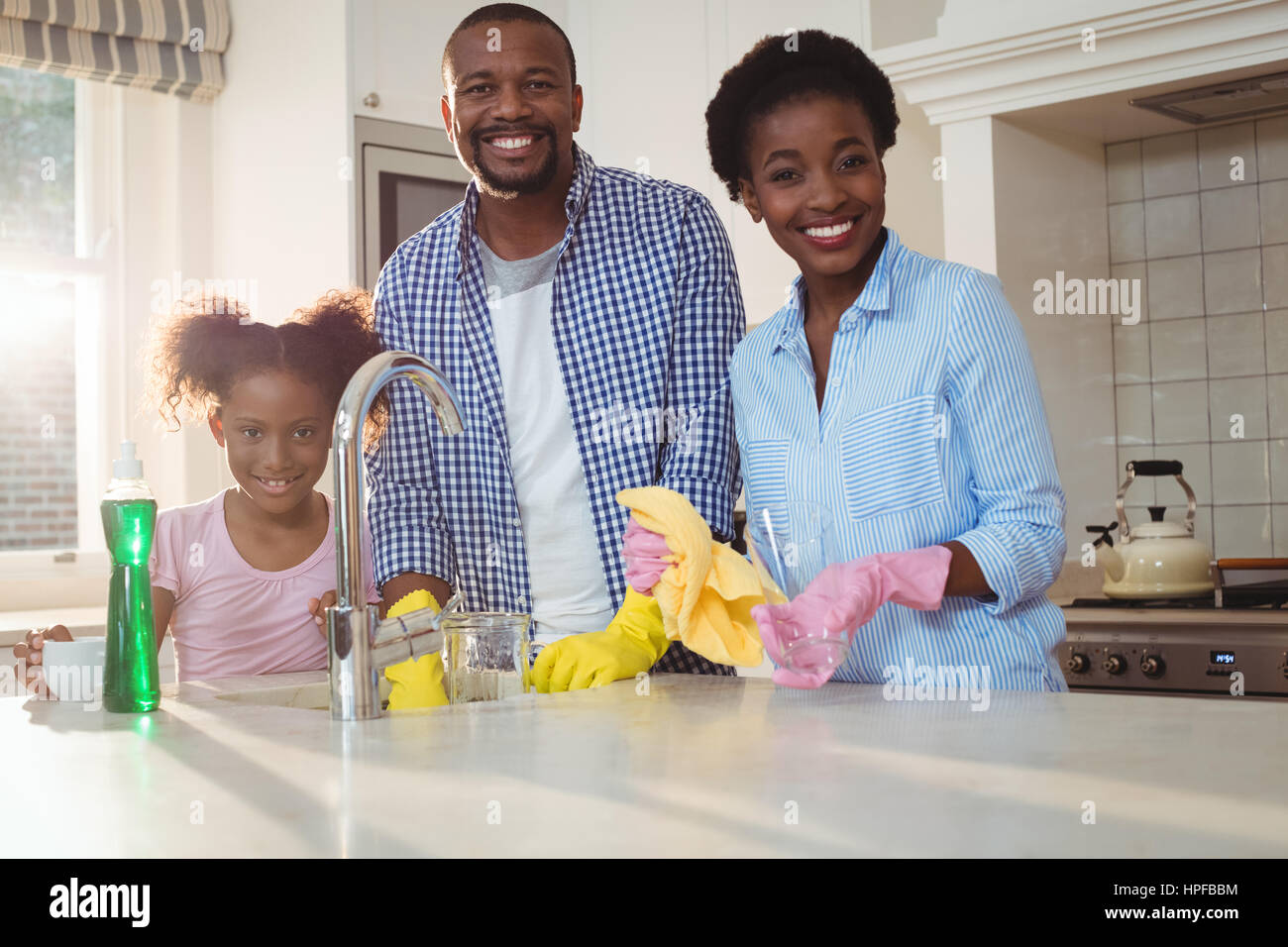 Portrait of family washing utensils in kitchen sink at home Stock Photo ...