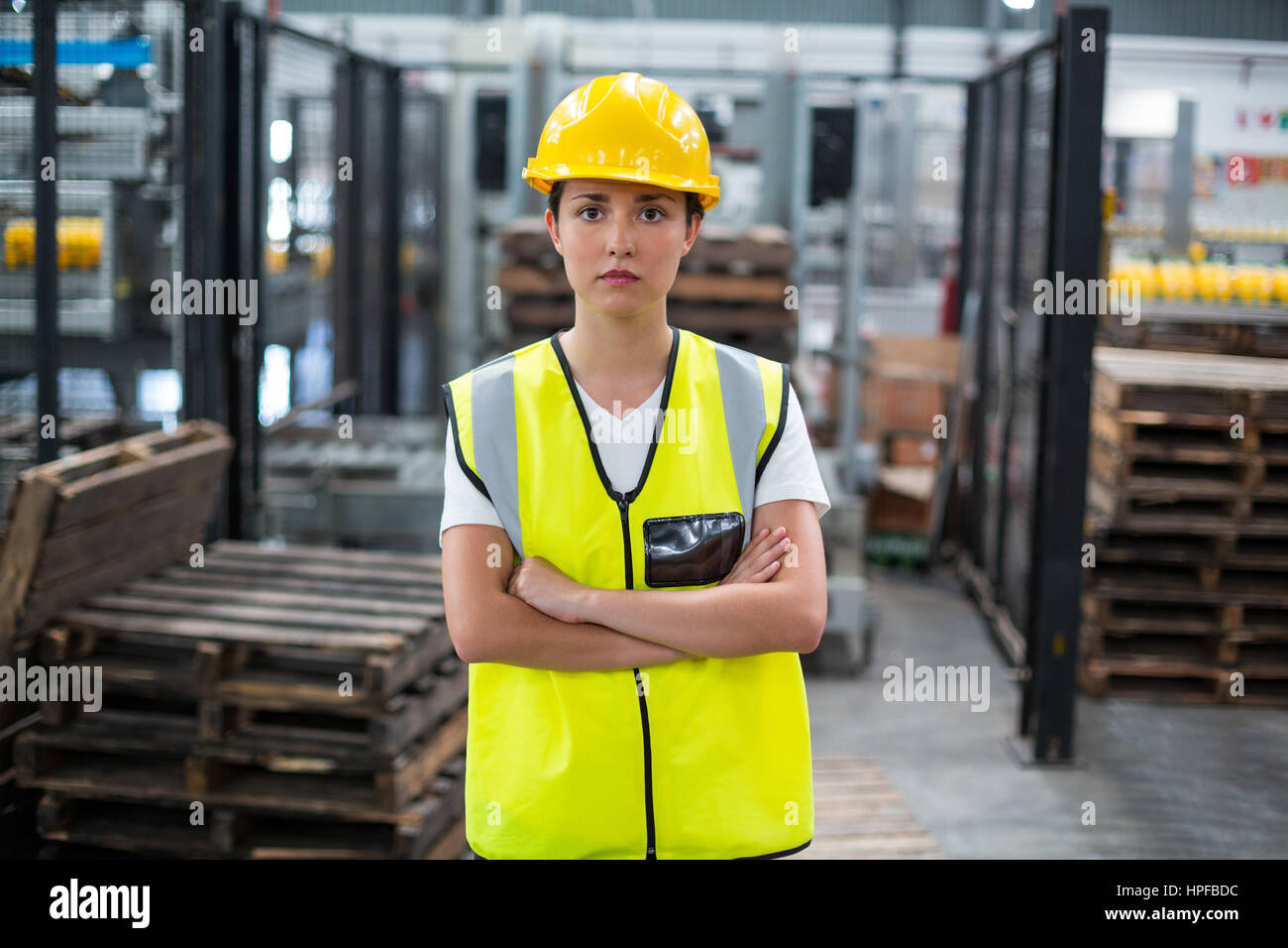 Portrait of female worker standing with arms crossed in factory Stock ...