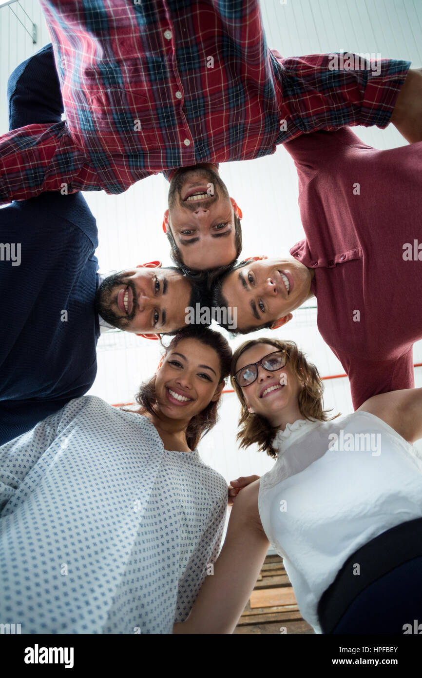 Team of businesspeople forming huddle in office Stock Photo - Alamy