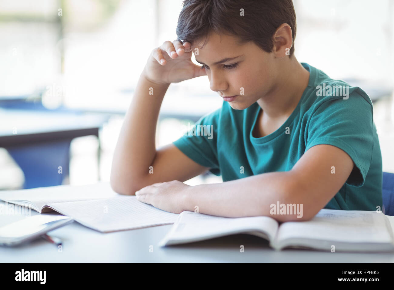 Attentive schoolboy studying in classroom at school Stock Photo - Alamy