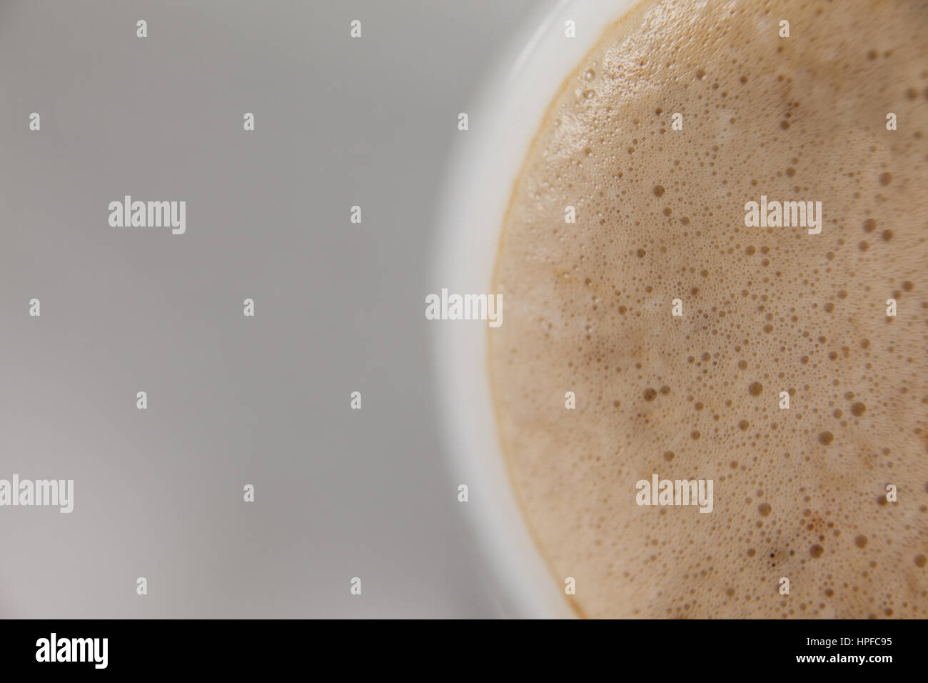 Close-up of white mug of coffee with creamy froth on white background ...