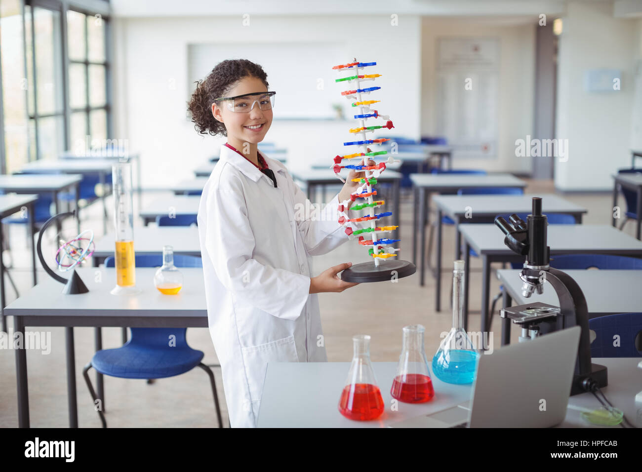 Attentive schoolgirl experimenting molecule model in laboratory at ...