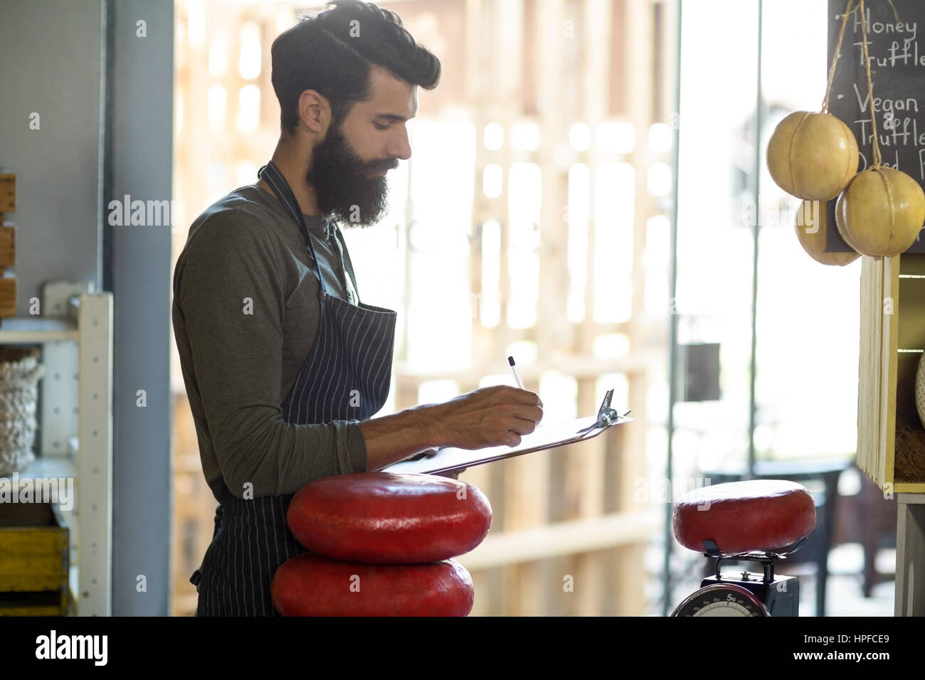 Salesman writing on clipboard at counter in grocery shop Stock Photo ...
