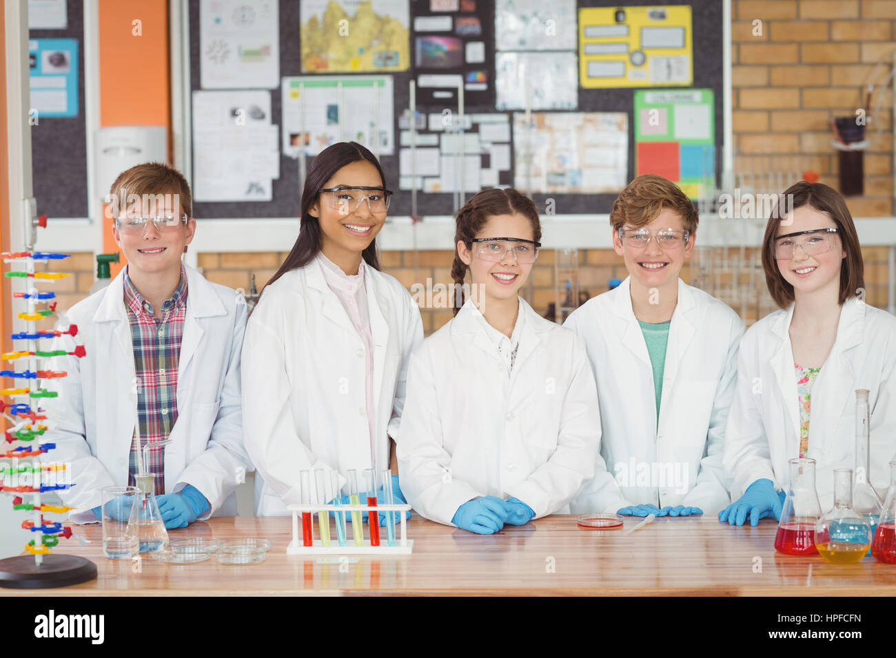 Portrait of school kids doing a chemical experiment in laboratory at ...