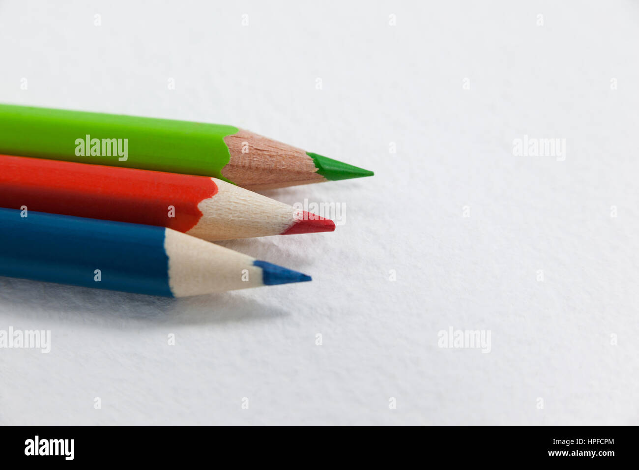 Close-up of three colored pencils on white background Stock Photo - Alamy