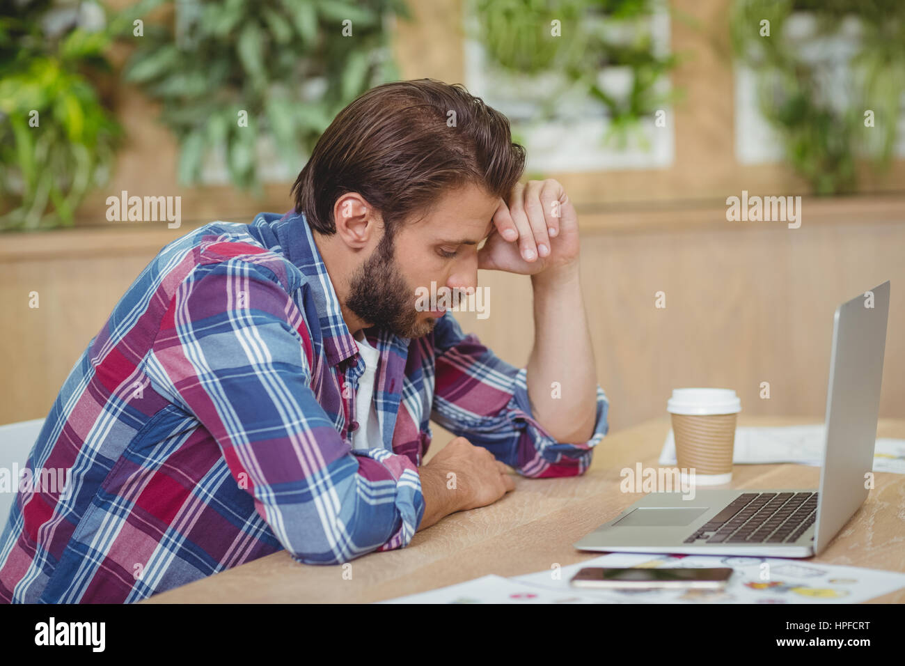 Tensed Executive with laptop siting at desk in office Stock Photo - Alamy