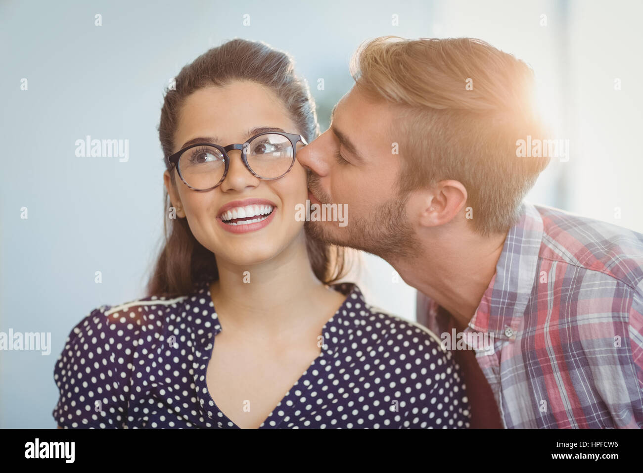 Woman kissing male colleague hi-res stock photography and images - Alamy