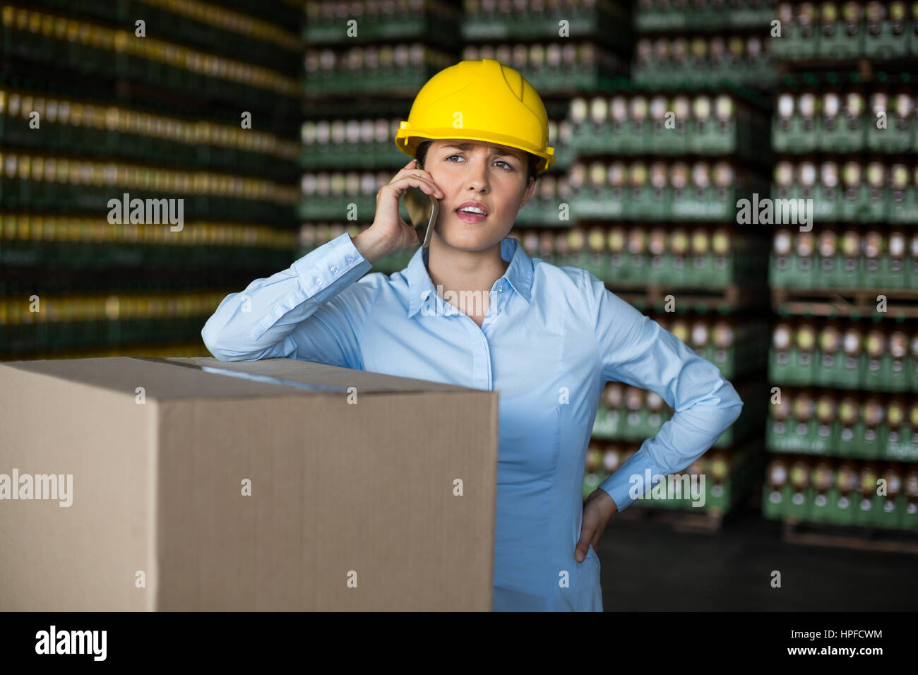 Female factory worker talking on mobile phone in factory Stock Photo ...