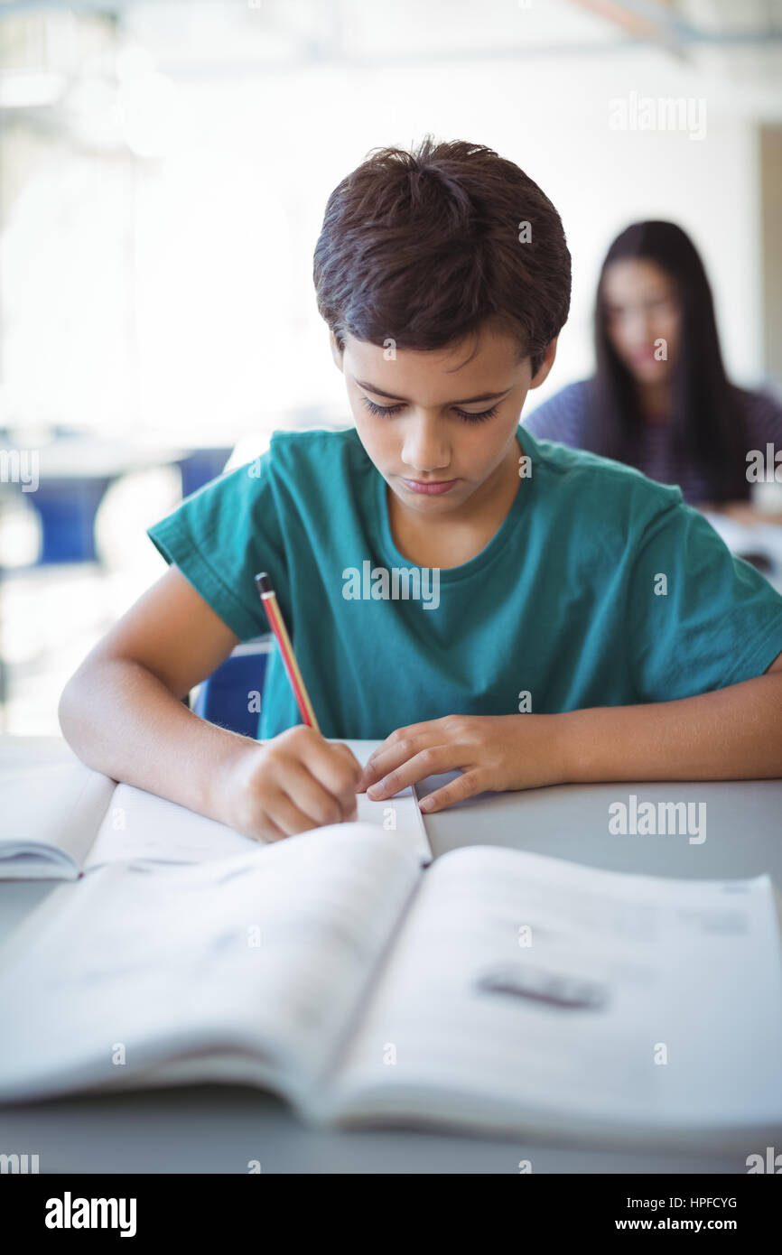 Schoolboy doing homework in classroom at school Stock Photo - Alamy