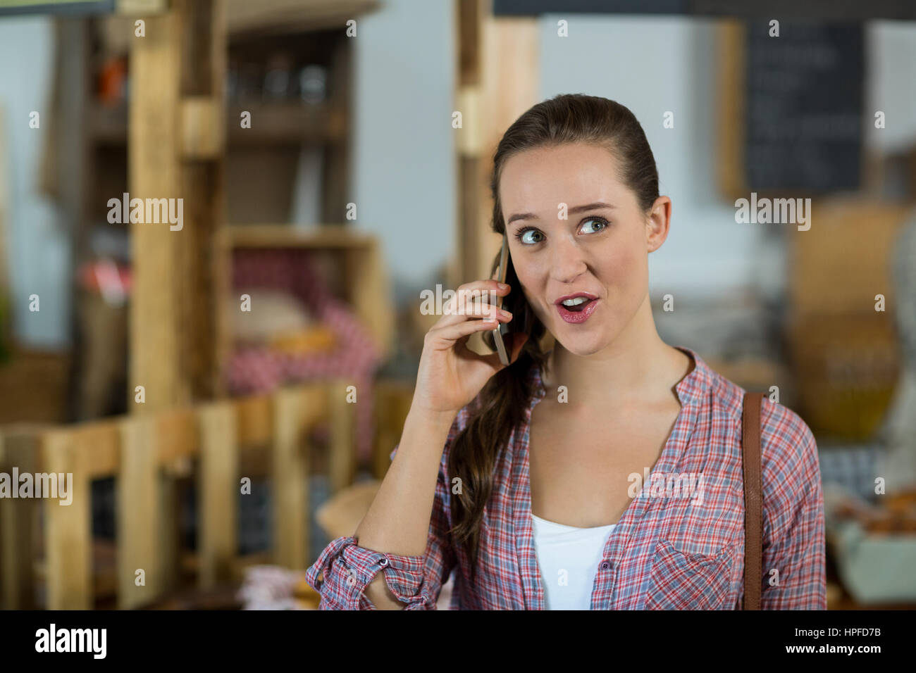 Female customer talking on the phone in grocery shop Stock Photo - Alamy