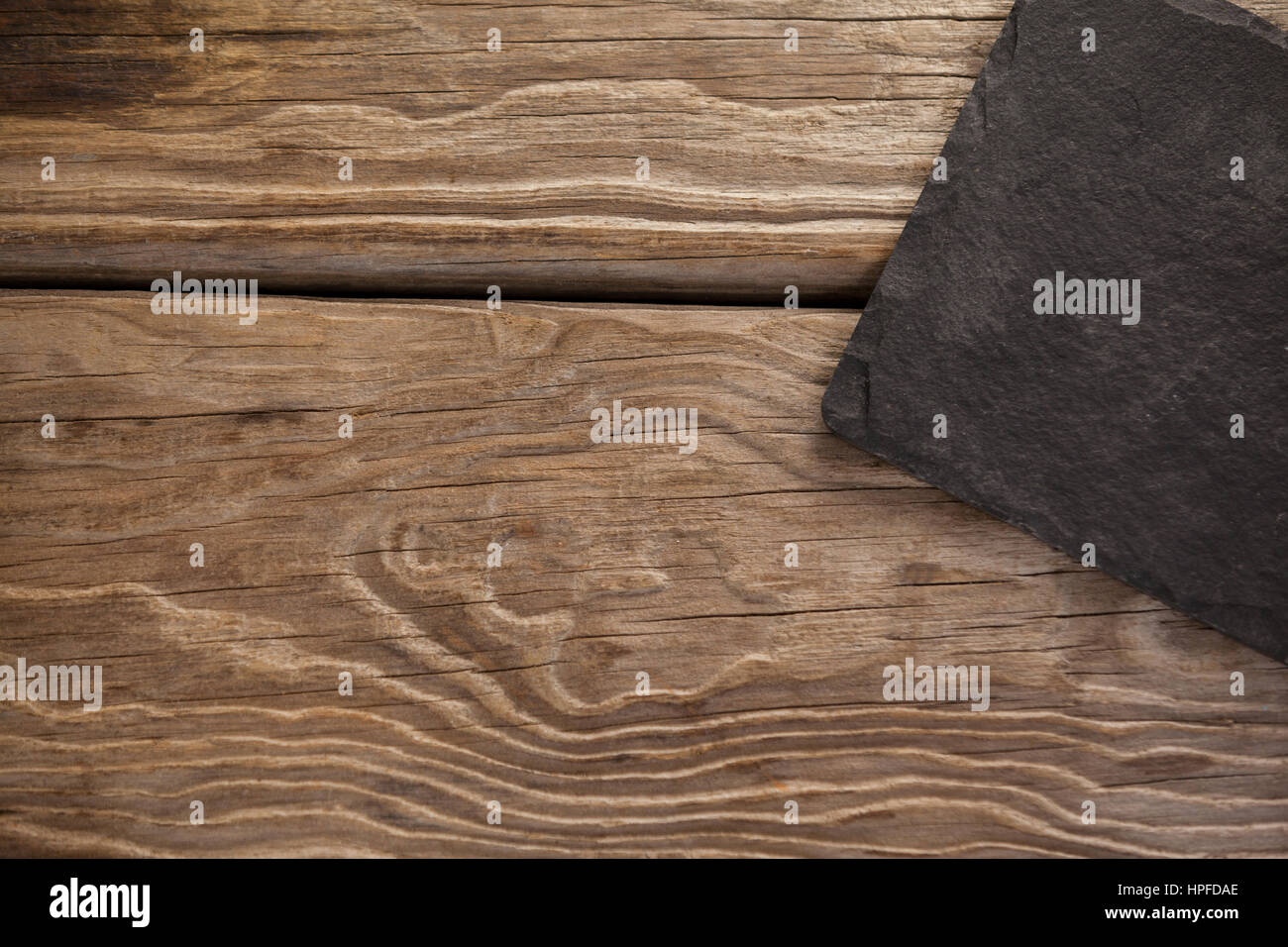 Black slate plate against wooden background Stock Photo - Alamy