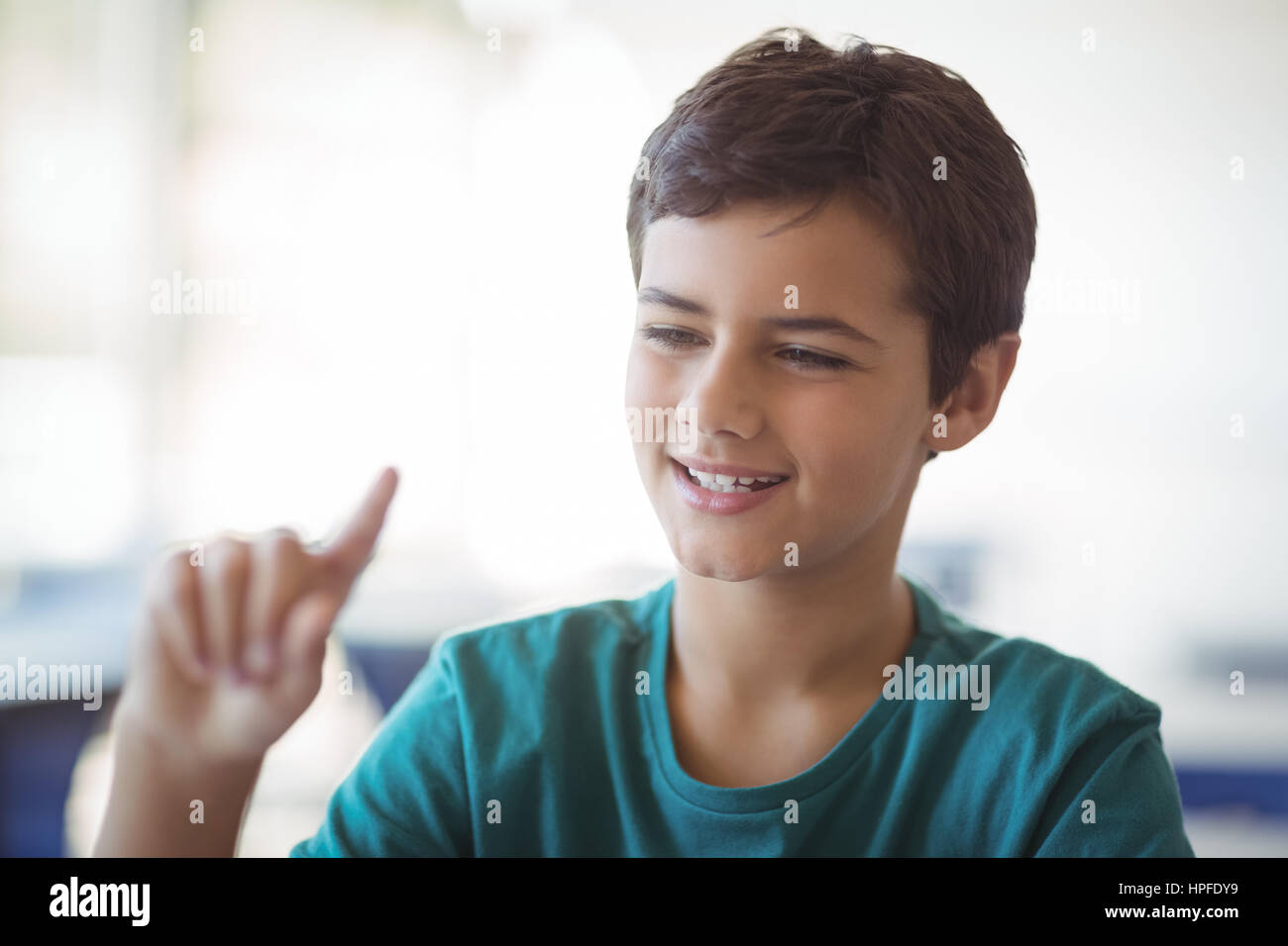 Attentive schoolboy gesturing in classroom in school Stock Photo - Alamy