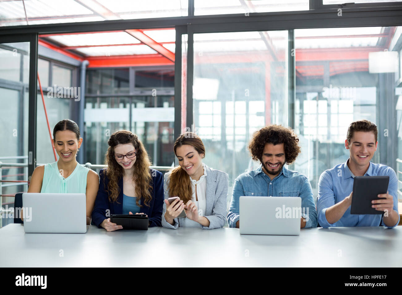 Smiling business team working together in meeting at office Stock Photo ...