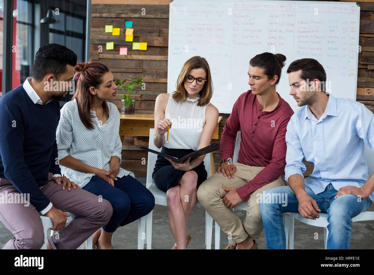 Business executives discussing over file during meeting in office Stock ...
