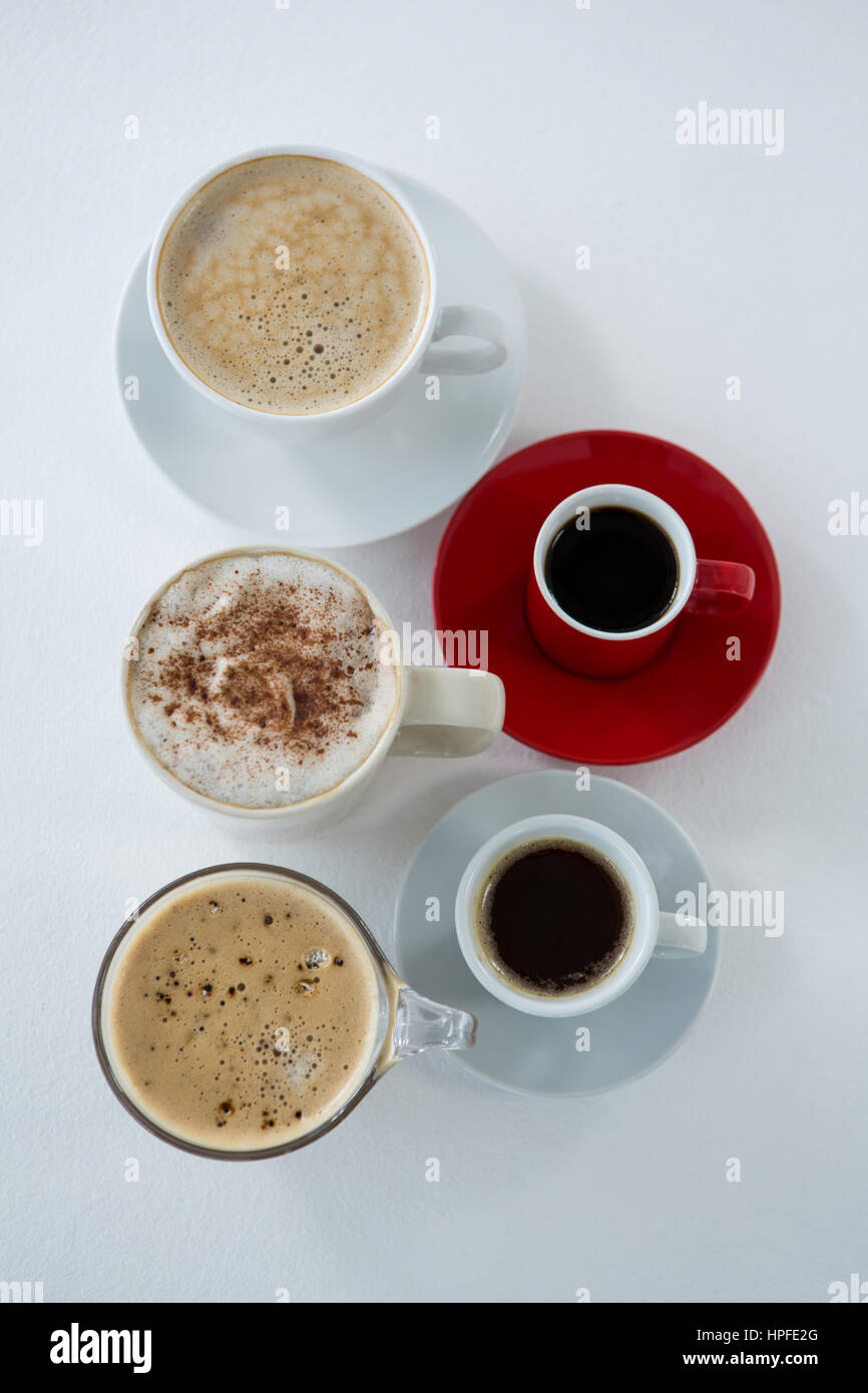 Top view of different types of coffee in cups arranged on white ...